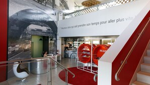 Um interior moderno com escada, um mural e um detalhe circular vermelho.