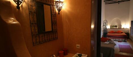 Casa de banho com lavatório, espelho e luzes decorativas na parede.