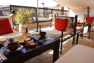 Uma sala de jantar com uma mesa posta para o café da manhã, incluindo pratos, tigelas e copos.
