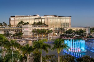 Um hotel Sheraton com uma grande fonte e palmeiras em primeiro plano.