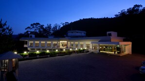 Um hotel moderno com um pátio amplo, várias acomodações e uma entrada bem iluminada.