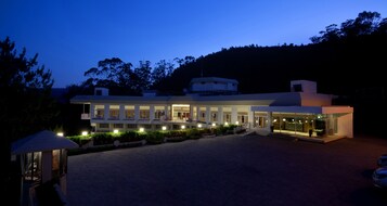 Um hotel moderno com um pátio amplo, várias acomodações e uma entrada bem iluminada.