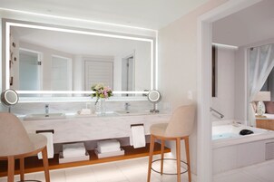 Casa de banho moderna com um espelho grande, duas pias, uma banheira e uma cómoda com espelho.