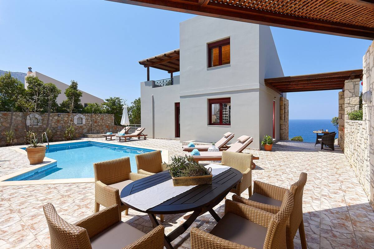 Uma villa moderna com piscina, área de estar ao ar livre e vista para o mar.
