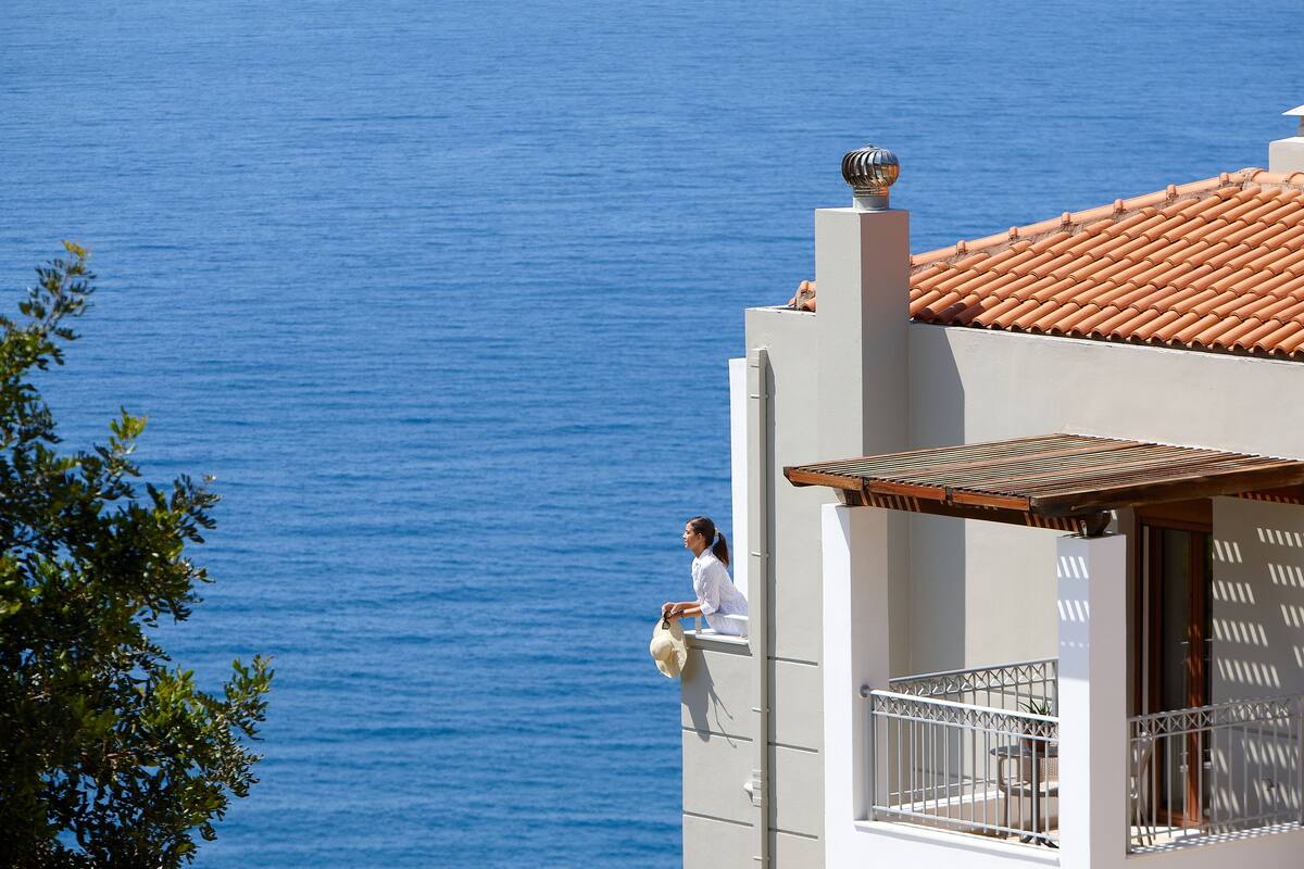 Um edifício com varanda com vista para um corpo de água.