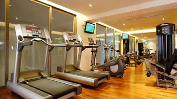 Uma academia com esteiras, elípticos e equipamentos de musculação.