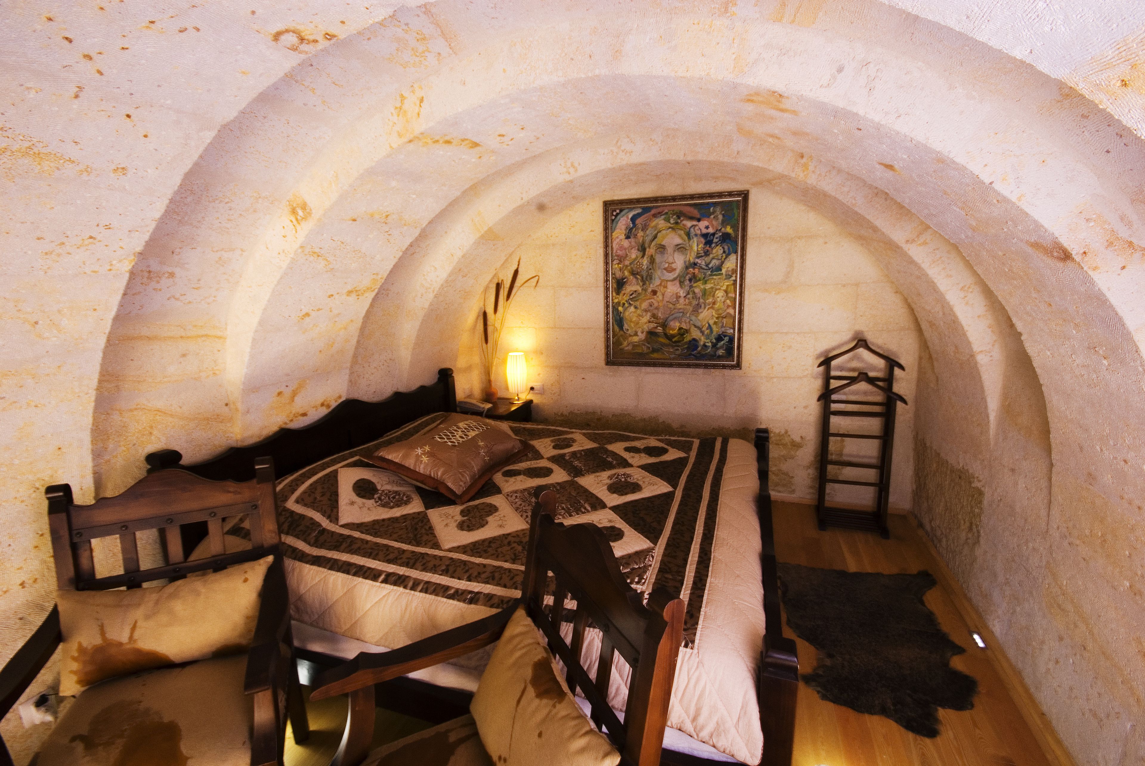 Um quarto aconchegante e rústico, com uma cama, móveis de madeira, um quadro e uma escada.