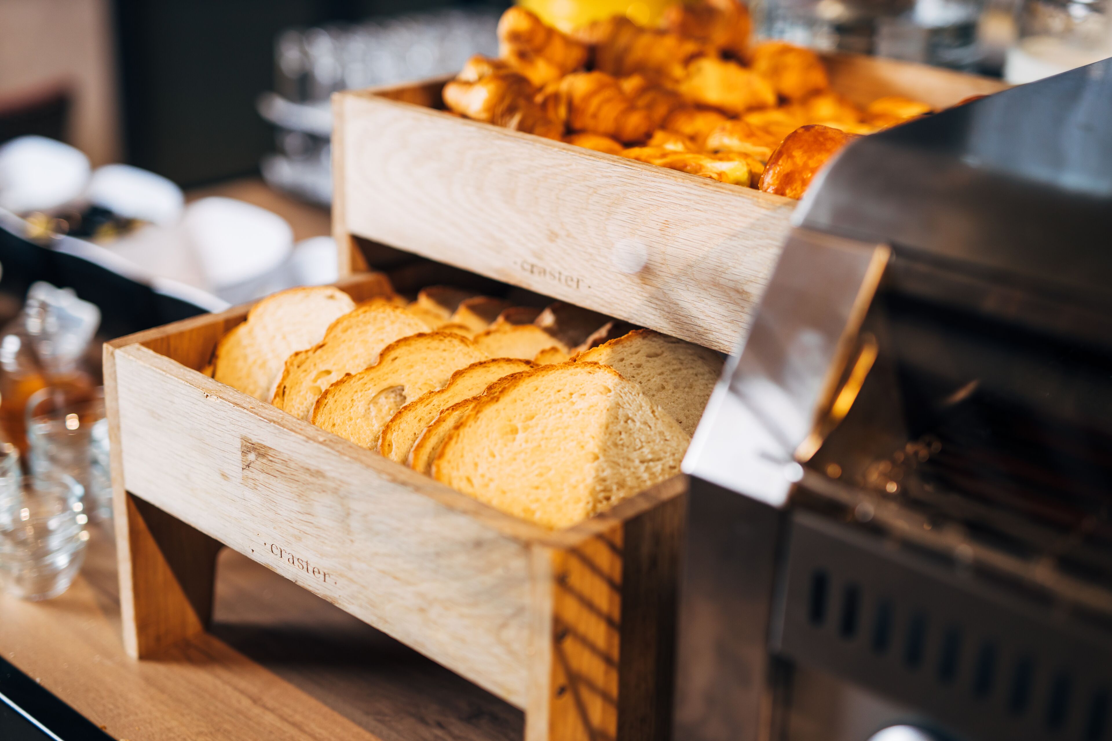 Cestos de pão de madeira em uma bancada com uma máquina de café.