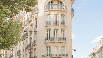 Um edifício histórico com cúpula e varandas ornamentadas, com área de estar ao ar livre e um café no andar térreo.