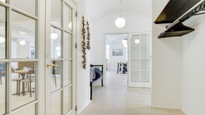 Um corredor com portas de vidro, um banco e decorações penduradas.