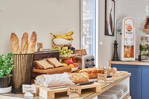 Vitrine de uma padaria com diversos pães, frutas e uma máquina de café.