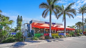 Um restaurante com toldo vermelho e uma placa que diz 'Taco Bar'.