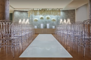 Preparação de cerimônia de casamento com cadeiras organizadas e um corredor branco.