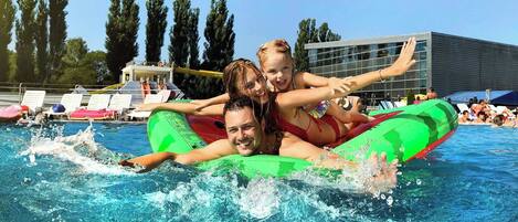 Piscina com pessoas aproveitando atividades aquáticas.