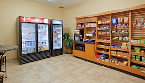 Refrigerador de bebidas com diversas opções e uma máquina de café.