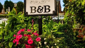 Placa indicativa para o 'Acara House B&B', com moldura preta e elementos decorativos.