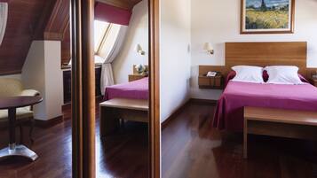 Quarto de hotel com teto de madeira, cama com roupa de cama rosa, um banco de madeira, uma mesinha e um quadro na parede.