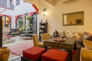 Interior acolhedor com área de refeições, assentos e uma estante de livros.