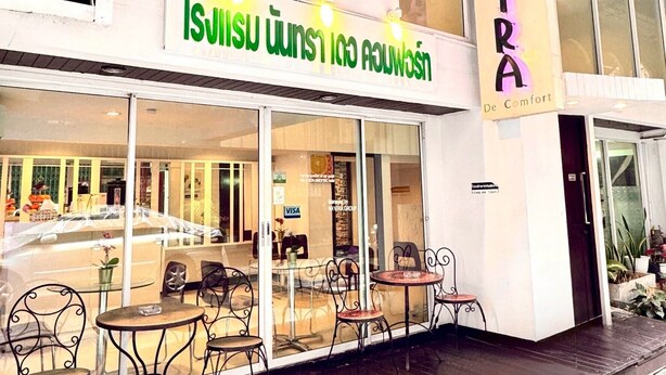 Restaurante com mesas ao ar livre e uma placa com a inscrição 'Tsunami'.