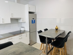 Um frigorífico/congelador grande, um micro-ondas, uma placa de cozinha 