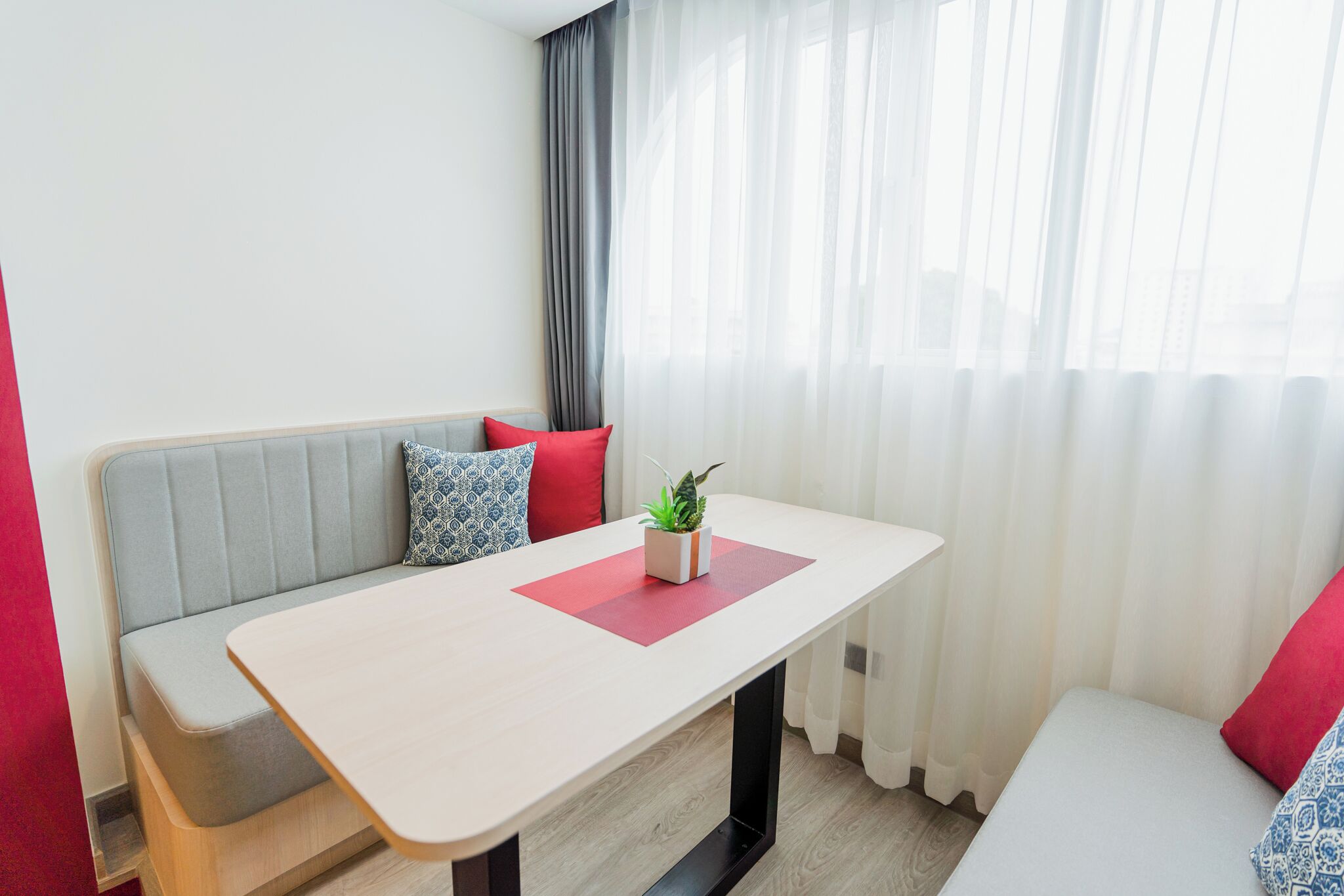Quarto moderno com sofá, uma mesinha e um vaso de planta.