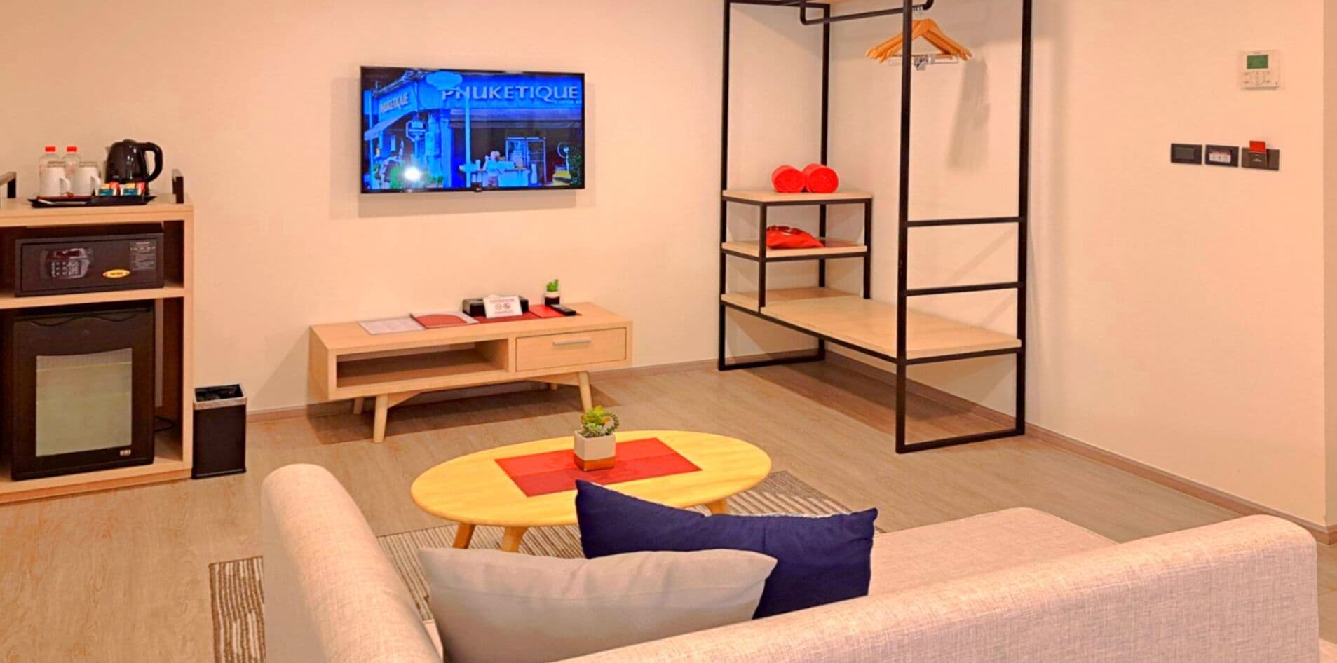Uma sala de estar moderna com sofá, mesa de centro, televisão e uma pequena estante.