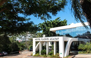 Uma entrada de hotel moderna com uma placa visível indicando "HOTEL CASINO ACARAY".