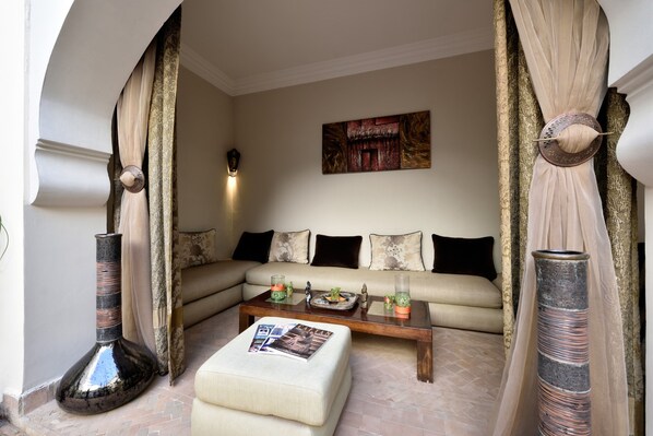 Sala de estar com sofá, mesa de centro e um vaso decorativo.