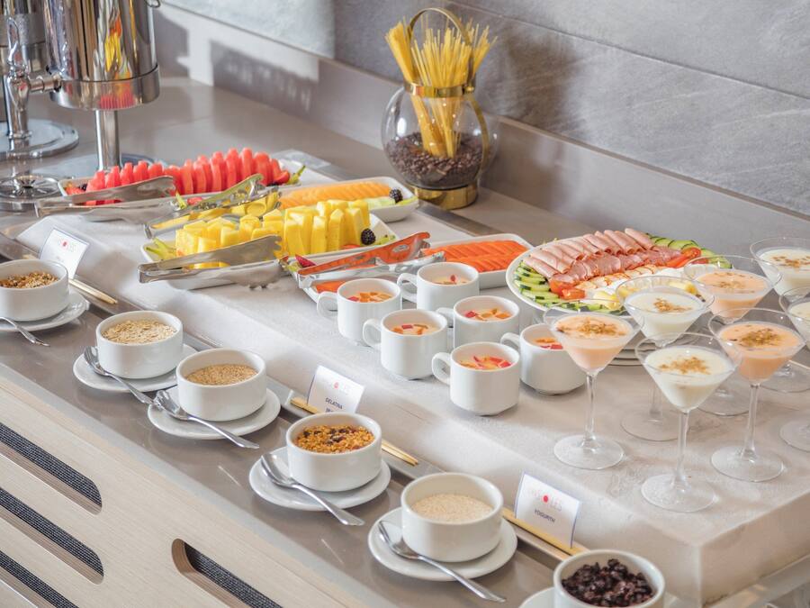 Uma mesa de buffet com diversos alimentos e bebidas.