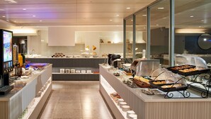Uma mesa de buffet com diversos alimentos e utensílios.