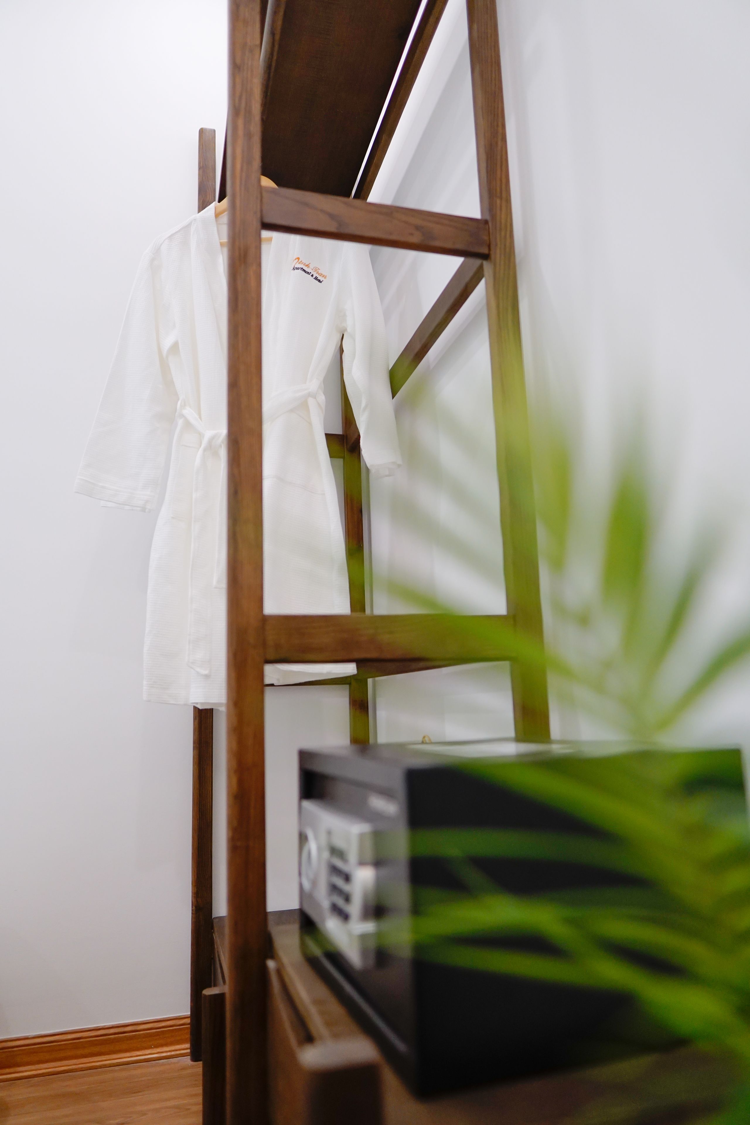 Uma cadeira de madeira com uma camisa branca pendurada.