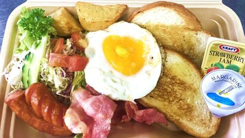 Refeição com torradas, ovo frito, bacon e uma salada acompanhada.