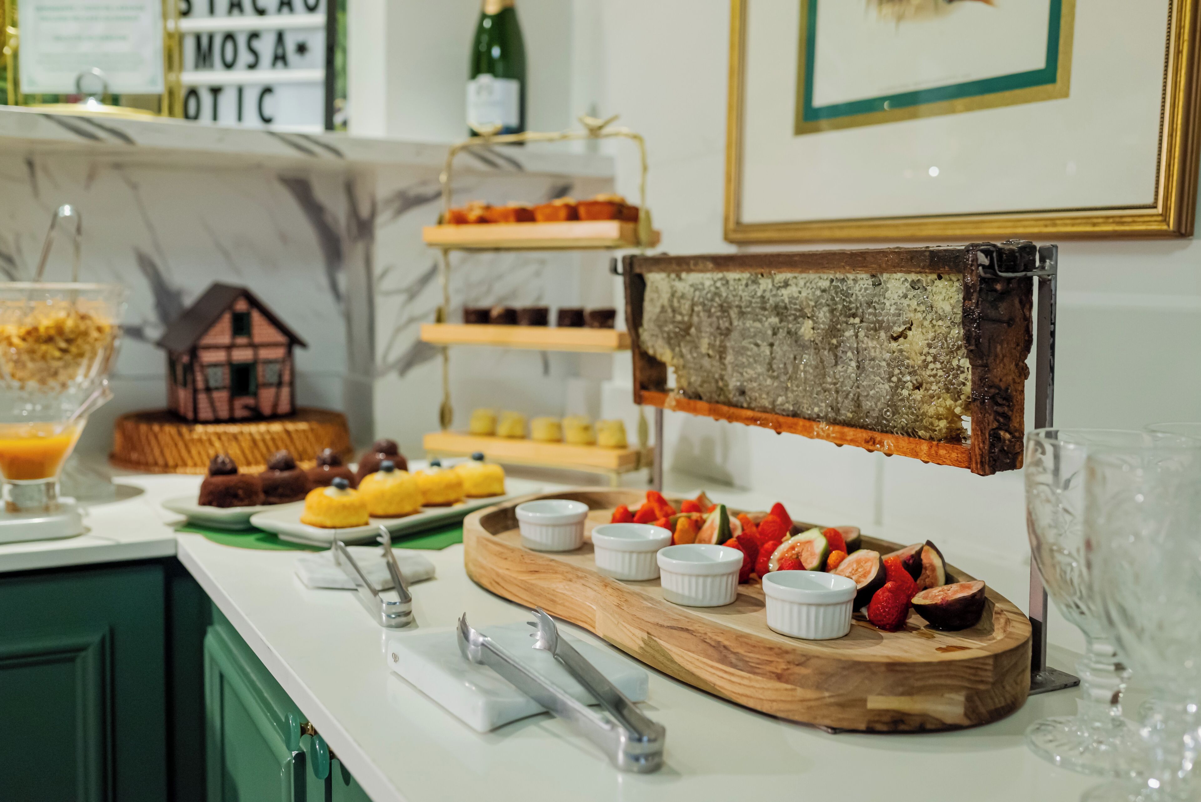 Buffet com diversos doces e uma garrafa de champanhe.