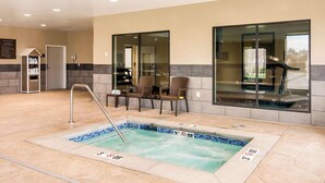 Uma área de piscina com hidromassagem, assentos e um pequeno quiosque.