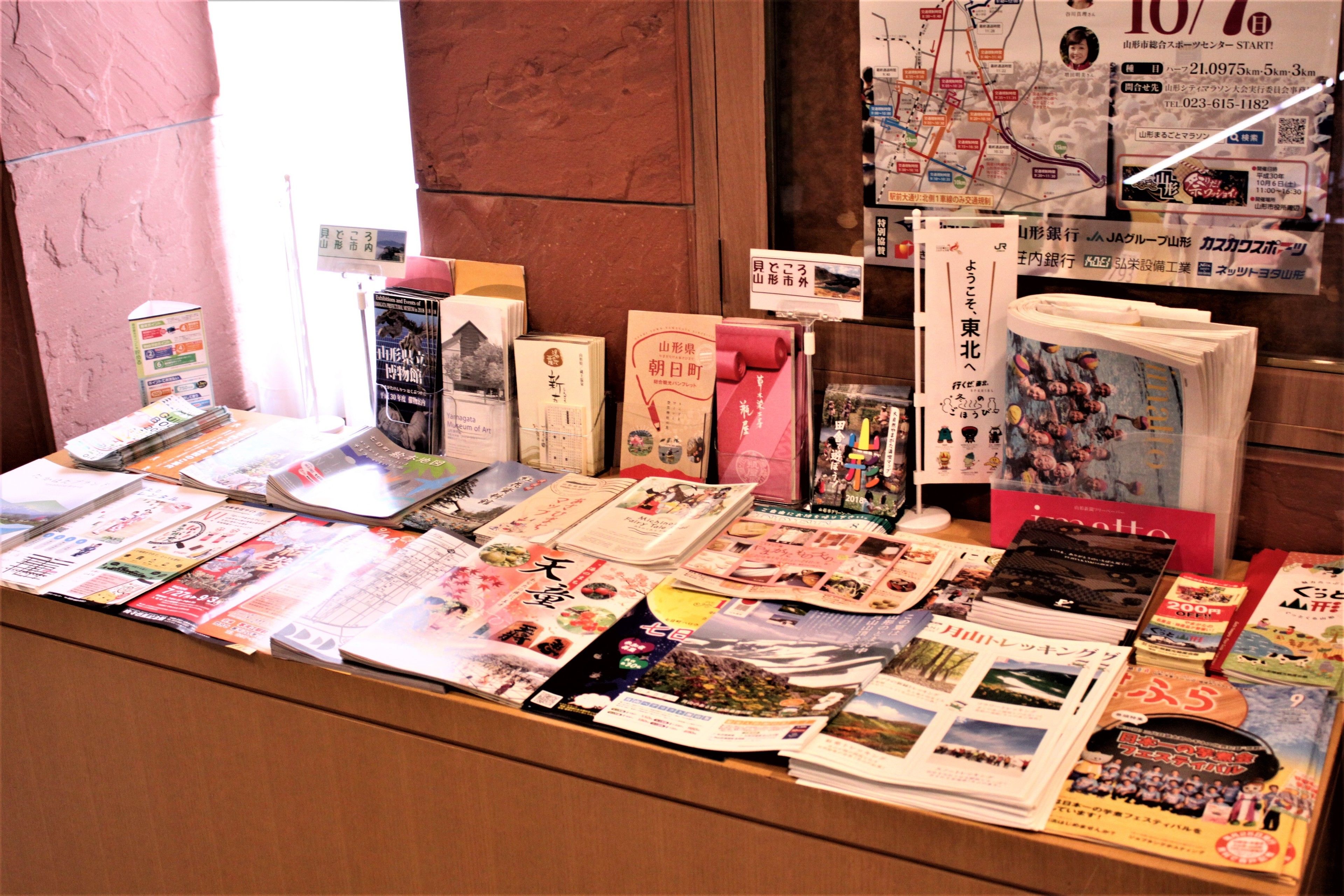 Exposição de vários livros e folhetos com texto em japonês, provavelmente materiais informativos ou promocionais.