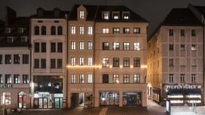 Um edifício com vários andares e sinalização iluminada, incluindo 