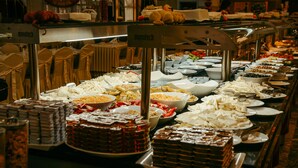 Buffet com diversas opções de comida e sobremesas.
