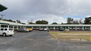 Um motel com várias salas, estacionamento e área gramada.