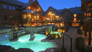 Um resort com piscina, área de estar externa e um edifício grande com várias varandas.