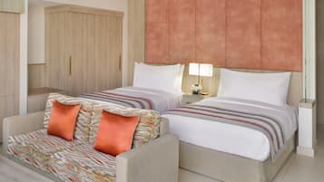 Quarto de hotel com duas camas, um sofá e um guarda-roupa.