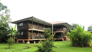 Uma casa de madeira de dois andares, com varanda no andar superior.