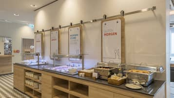 Uma área de buffet com estações de serviço identificadas para itens de café da manhã.