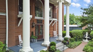 Um edifício de tijolos com colunas brancas e uma placa que diz 'James Madison Inn'.