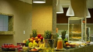 Um buffet com diversas frutas e bebidas.