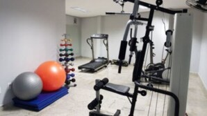 Uma academia em casa com equipamentos de ginástica, plataforma para exercícios e bolas de ginástica.