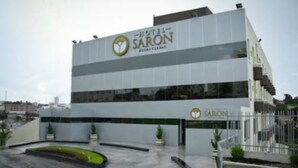 Um edifício de hotel moderno com um logotipo e o nome 'Saron' destacados na fachada.