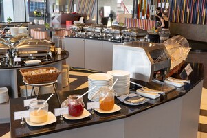 Uma mesa de buffet com diversos alimentos e utensílios.