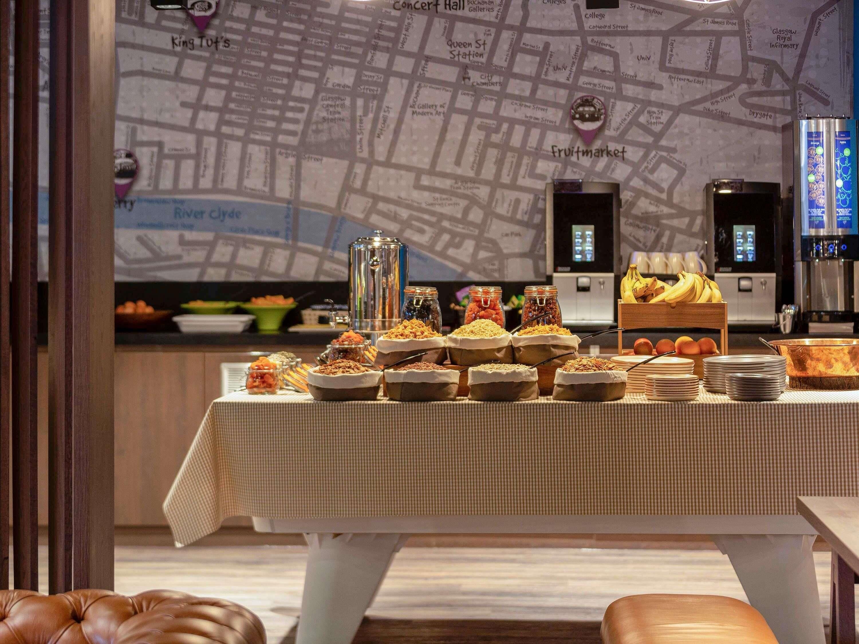 Uma mesa de buffet com diversos alimentos e um mapa ao fundo.