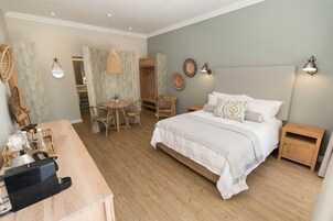 Quarto com uma cama, mesas de cabeceira, escrivaninha e uma cadeira.