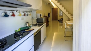 Cozinha moderna com fogão a gás, micro-ondas e suporte para panelas suspenso.